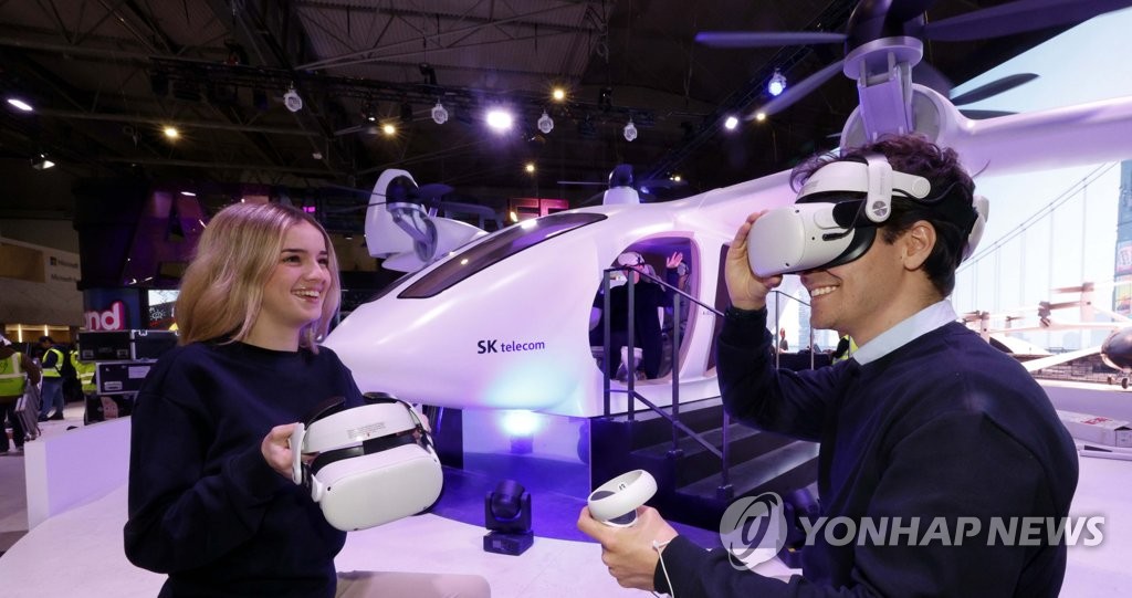 MWC SK텔레콤 전시관에서 UAM 모형 체험하는 관계자들 | 연합뉴스